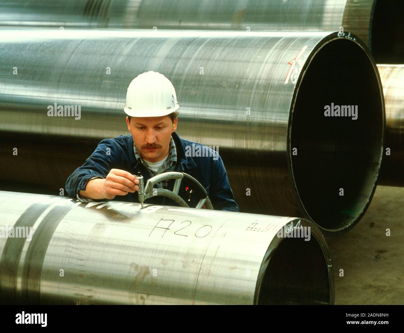 Measuring steel pipe. Worker checking the dimensions of a newly-made ...