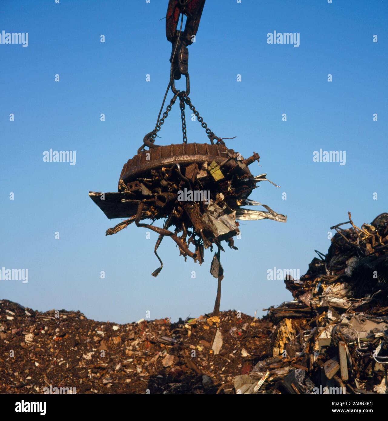 Scrap heap in London, UK, showing a large disklike electromagnet ...
