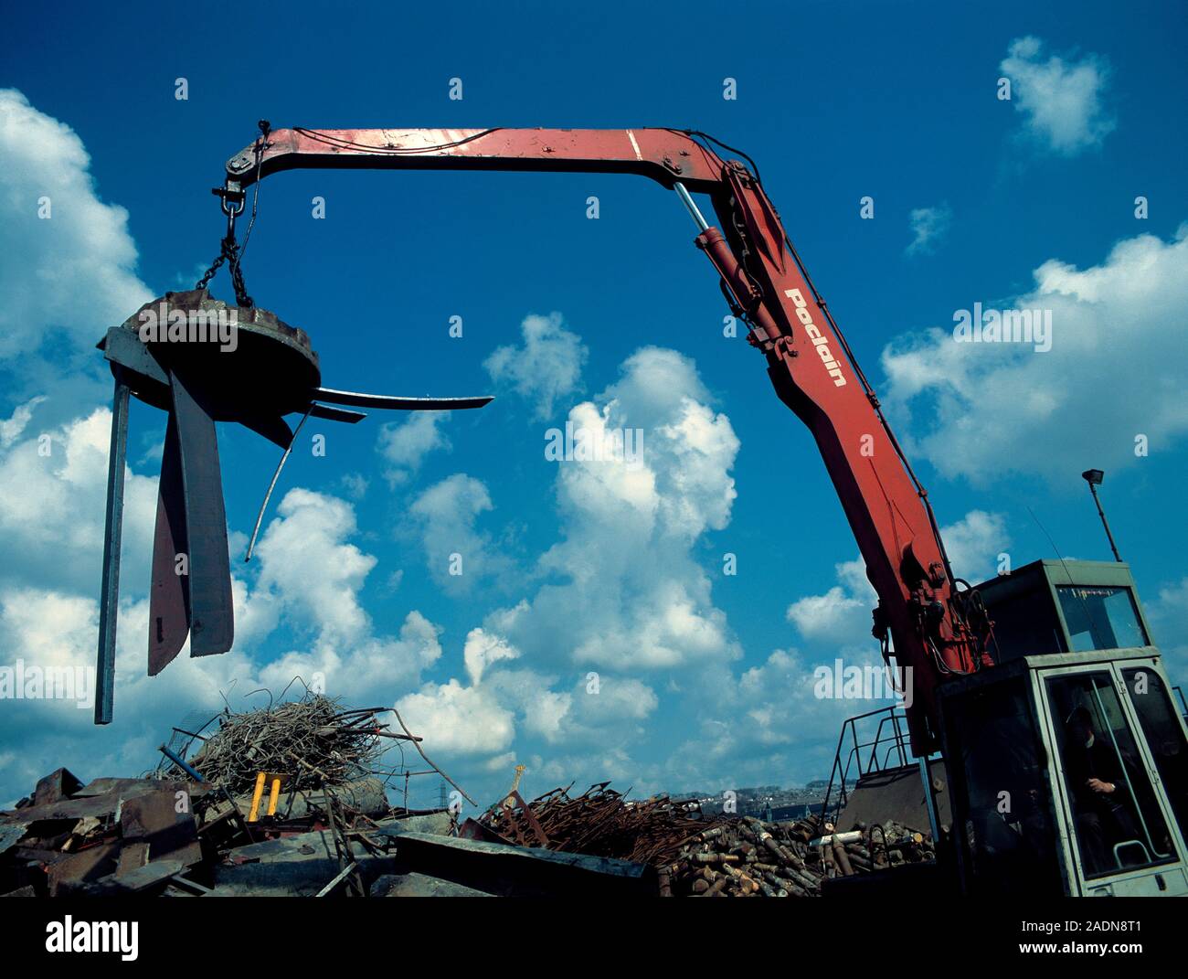 Large electromagnet being used to lift waste iron and steel at a ...