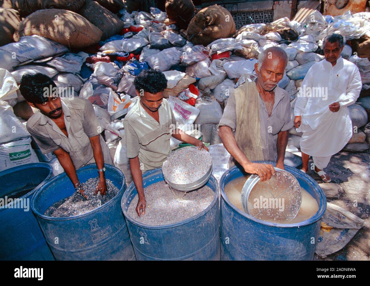 Plastics recycling. Asian men sorting plastic waste to separate out ...