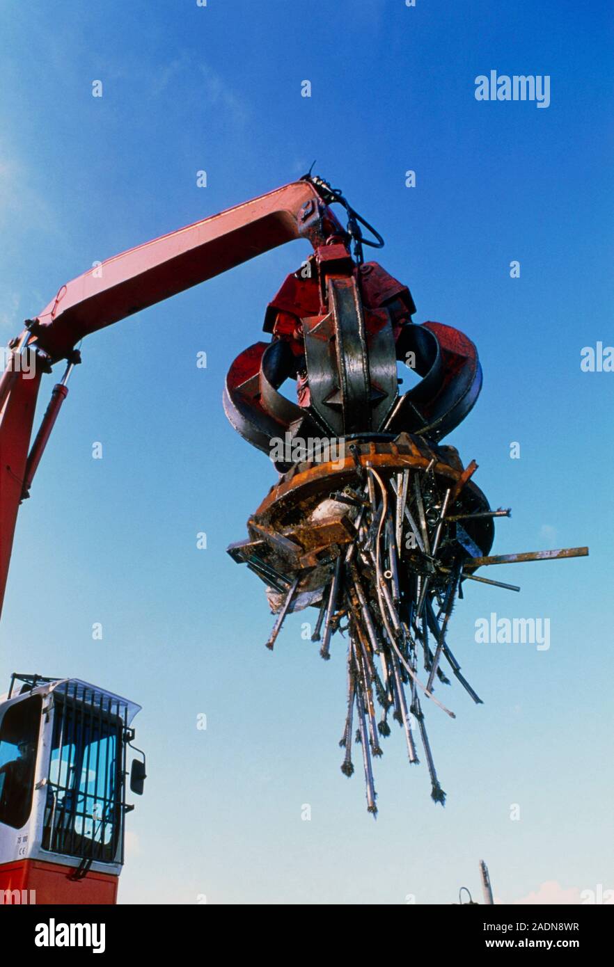 Scrapyard. View of a large electromagnet being used to lift waste iron ...