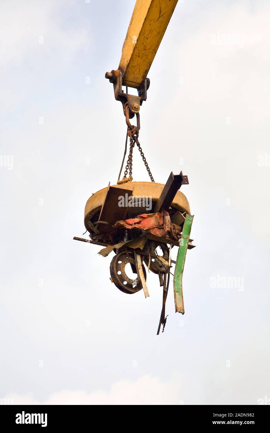 Electromagnet being used to lift ferrous metal (iron and steel) at a ...