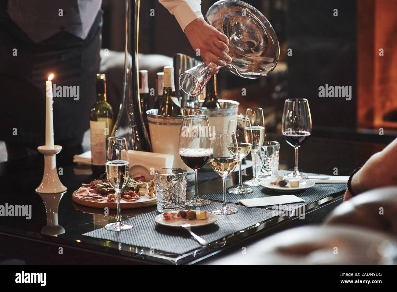 Waiter pouring wine at table hi-res stock photography and images - Alamy
