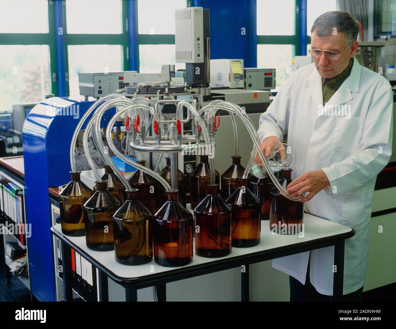 MODEL RELEASED. Water analysis. Chemist analysing samples of water for ...