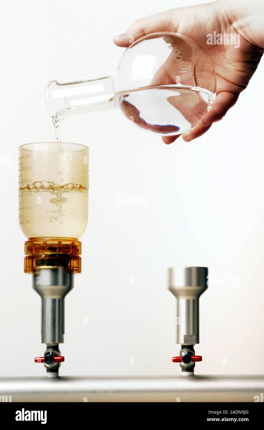 MODEL RELEASED. Drinking water test. Researcher pouring a sample of ...