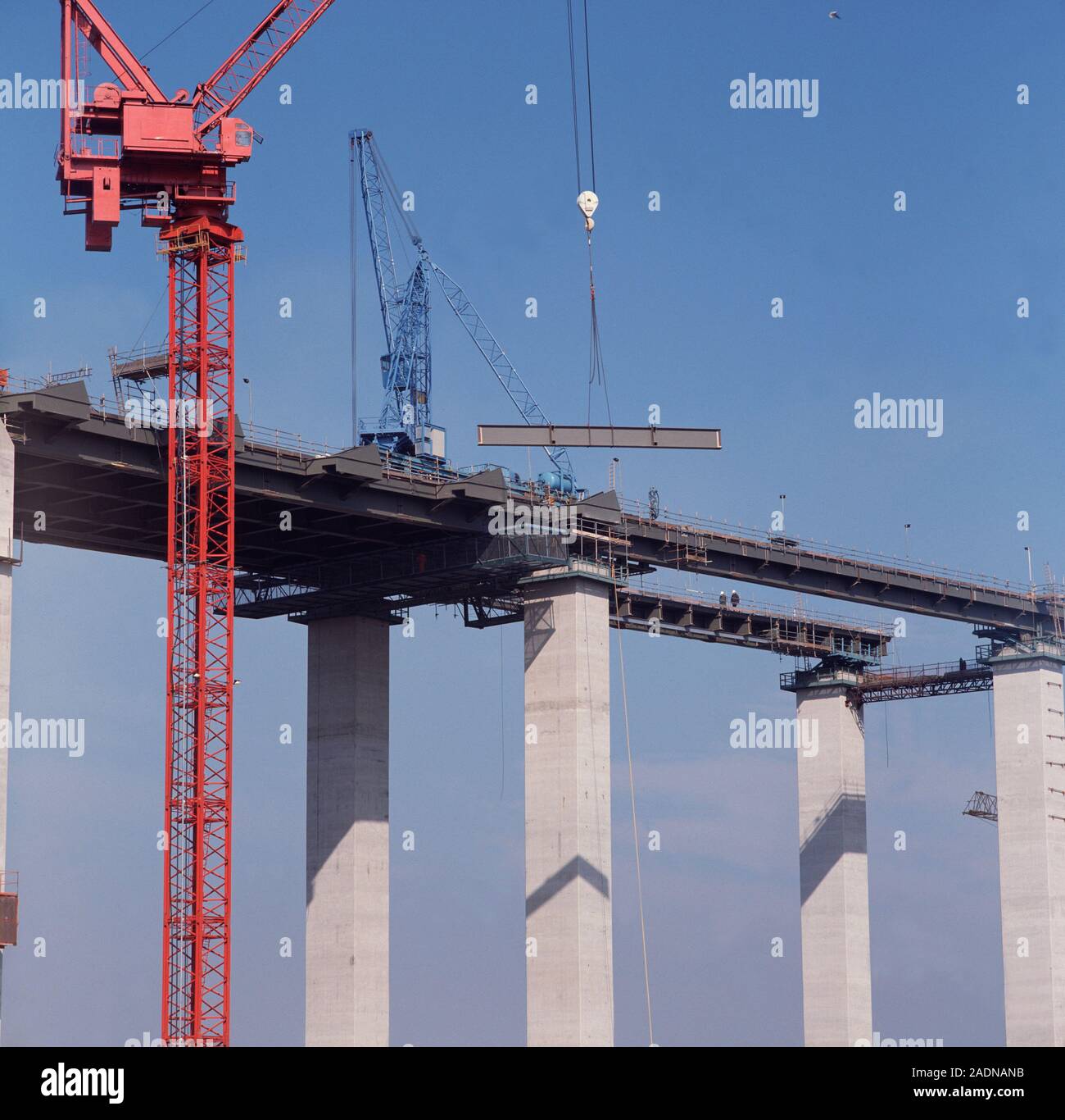 Bridge building. Crane lifting a girder during the construction of the ...