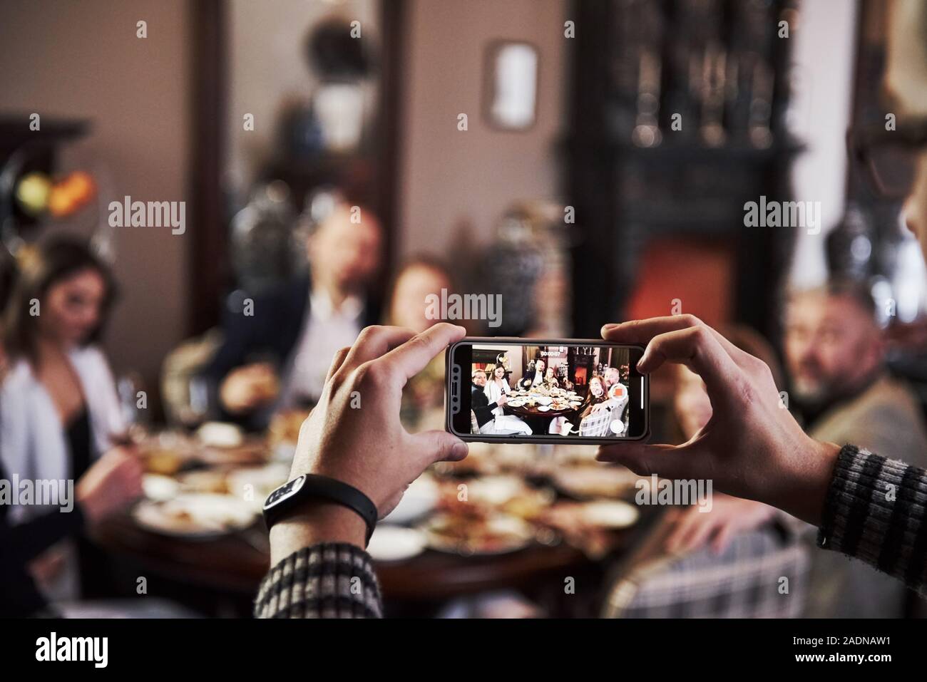 Taking group photo by using smartphone. Family friends having nice time ...