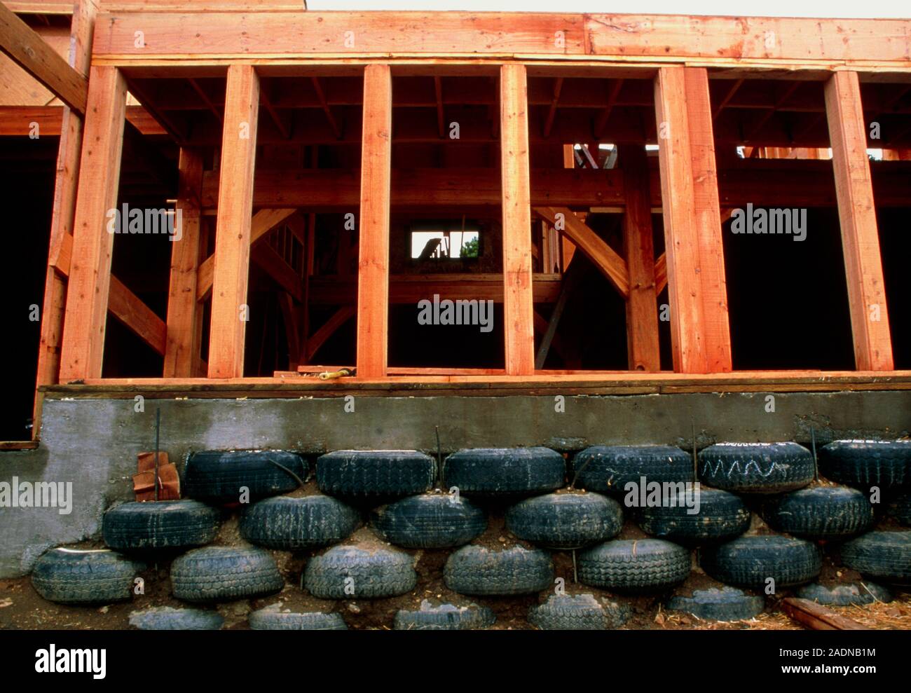 Tyre wall. Foundation wall made from concrete and used tyres below ...