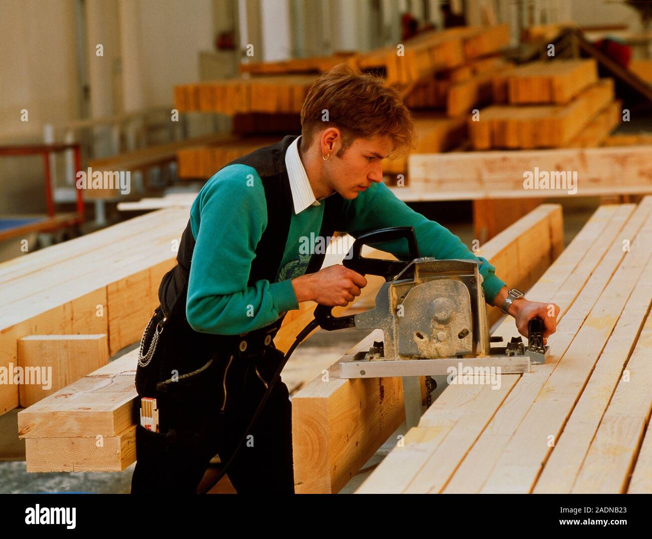 Carpentry. Carpenter uses a tool to shape rafters for the building ...