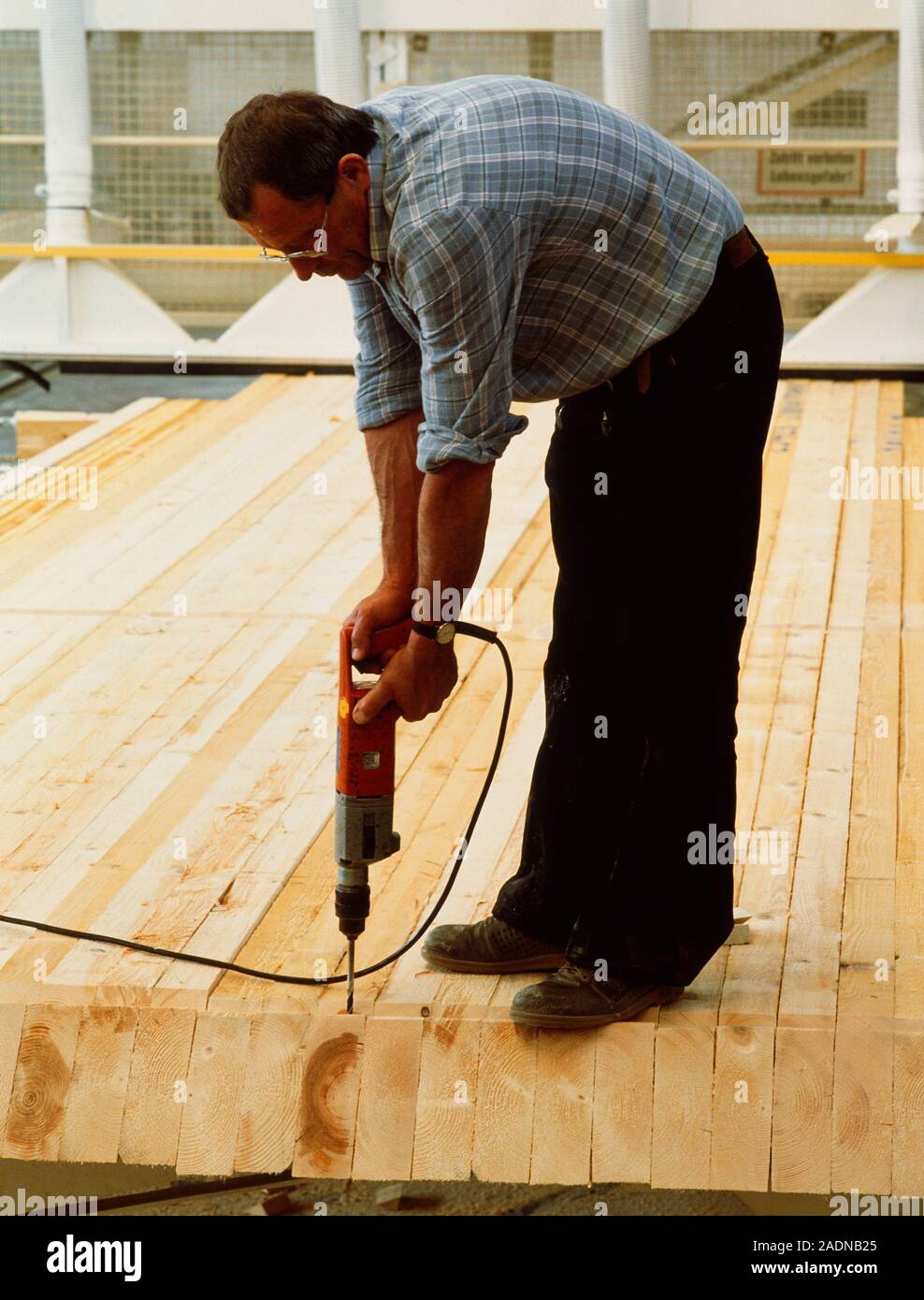 Carpentry. Carpenter uses a drill during the construction of rafters ...