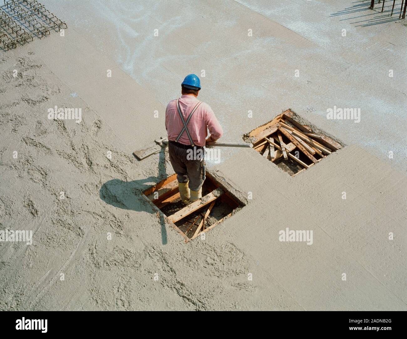 Building site. Construction worker smoothing out freshly laid ...