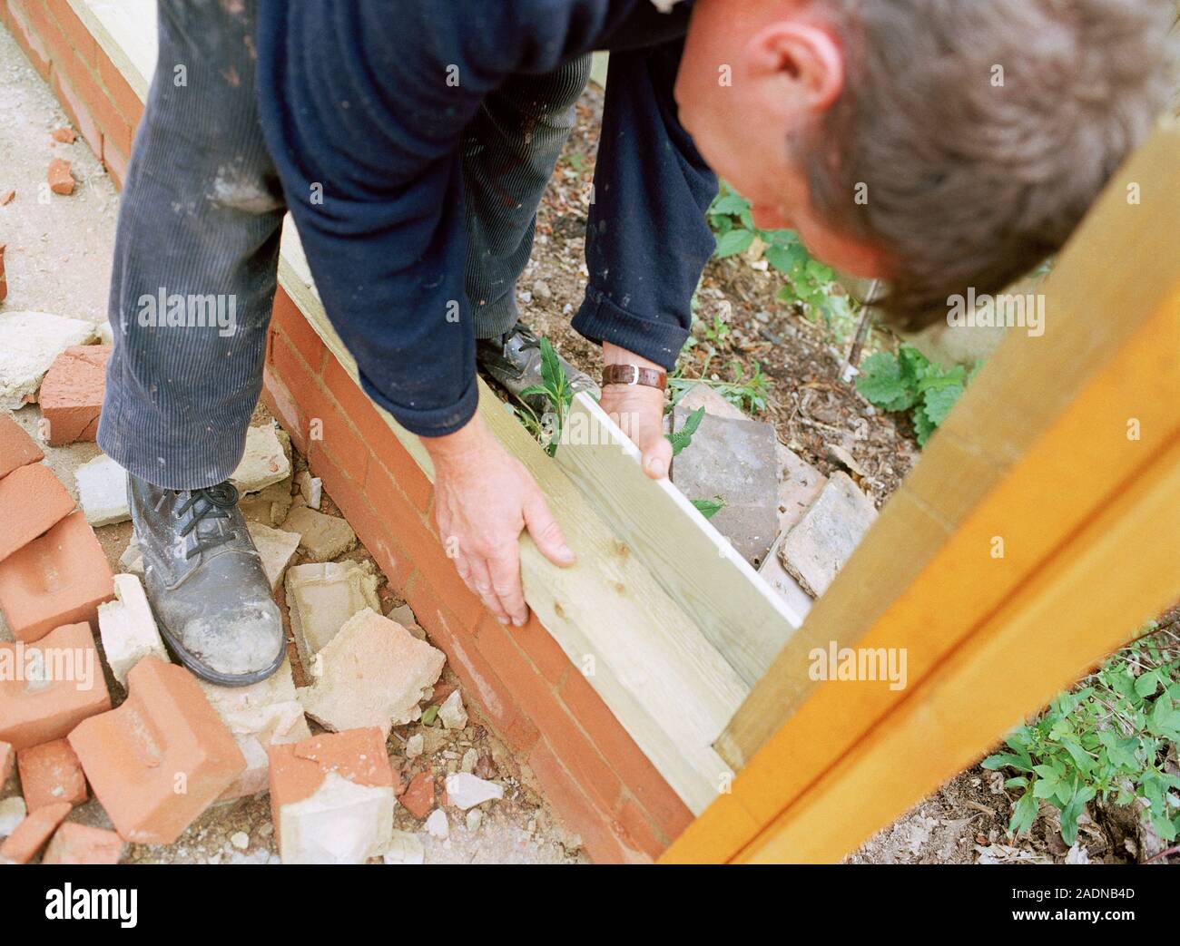 MODEL RELEASED. Man building a wall Stock Photo - Alamy