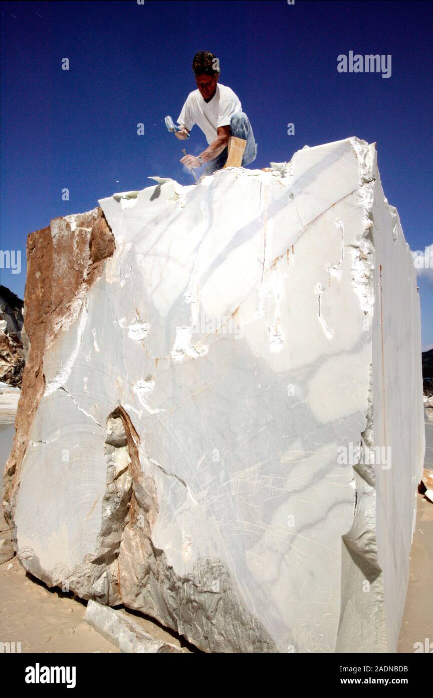 MODEL RELEASED. Marble quarry. Worker chiseling a block of marble at a ...