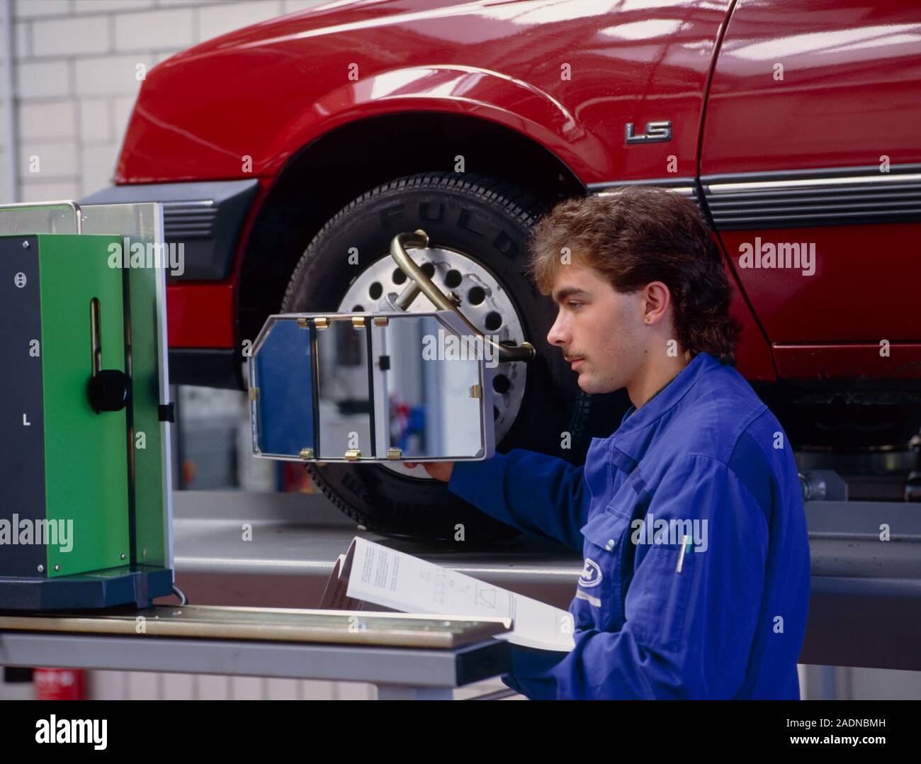 Suspension testing. Male technician checking a car's front suspension ...