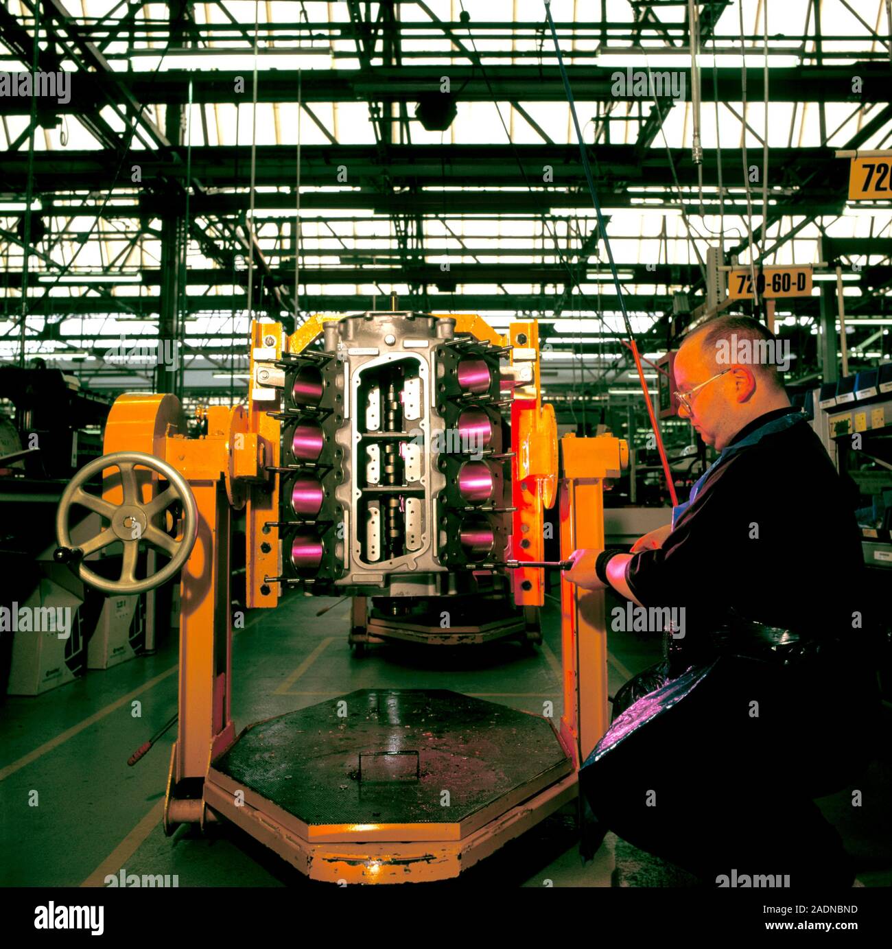 Engine block assembly. Worker assembling an engine block. Photographed ...