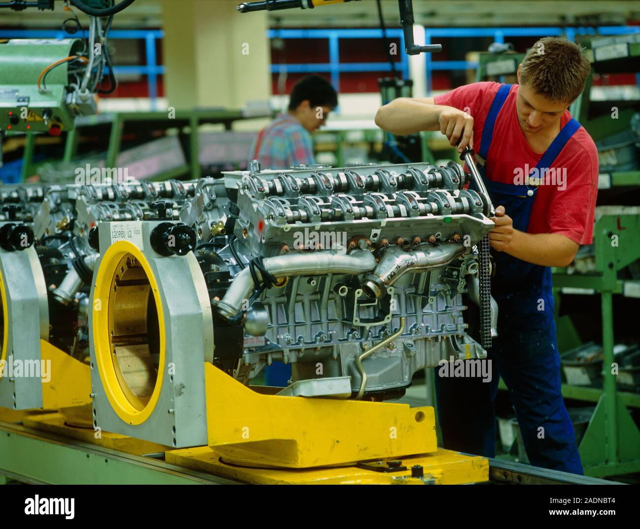 MODEL RELEASED. Car engine assembly. Mechanic assembling a car engine ...