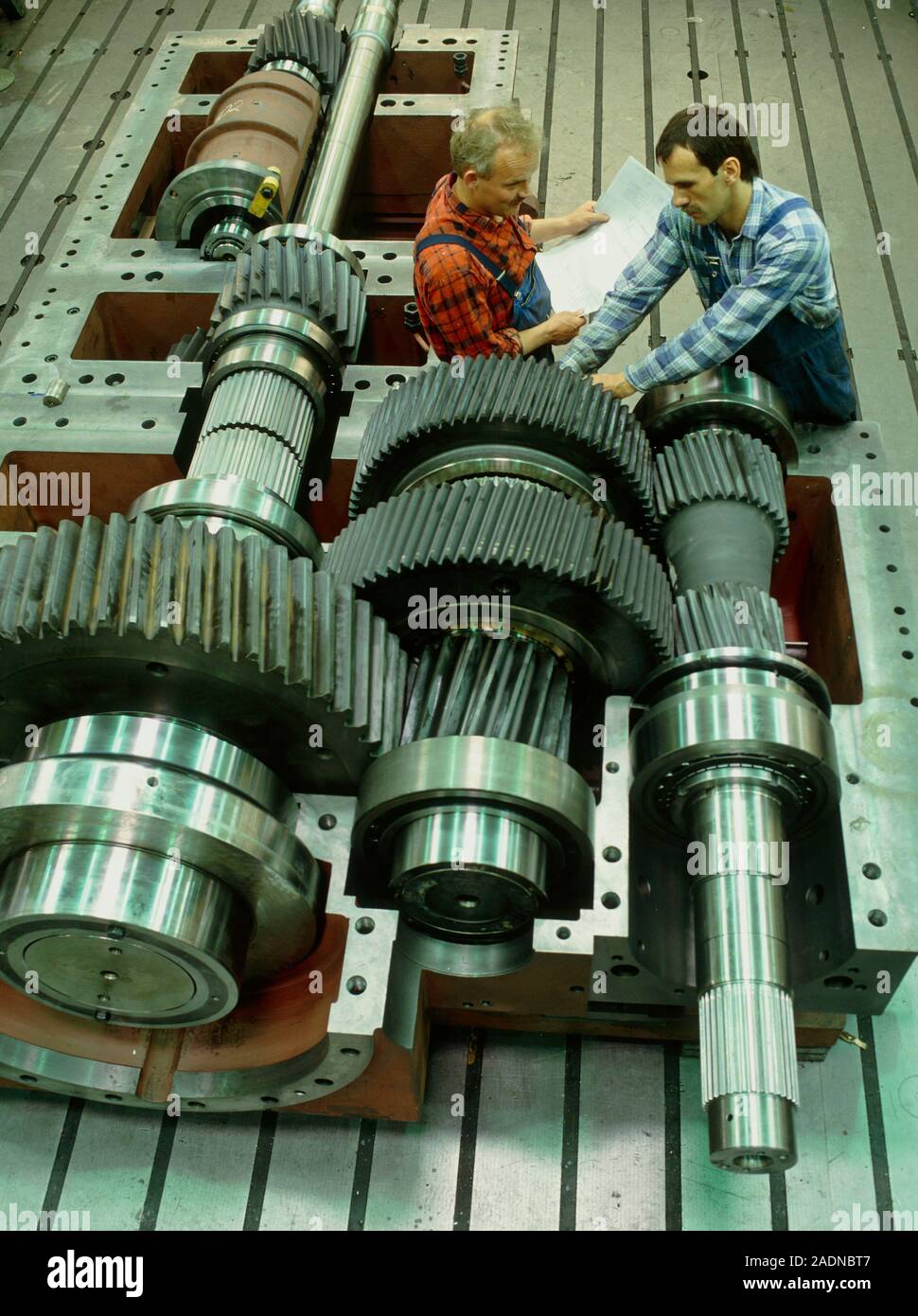 MODEL RELEASED. Gear production. Workers assembling gears for an engine ...
