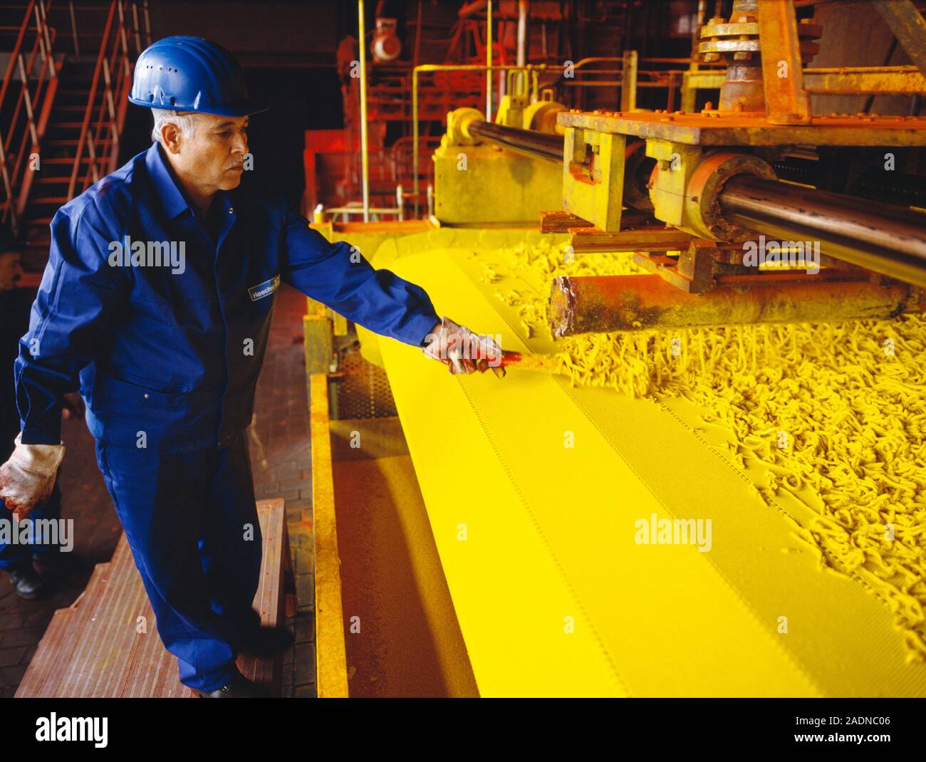 Paint pigment manufacture. Technician taking a sample from a production ...