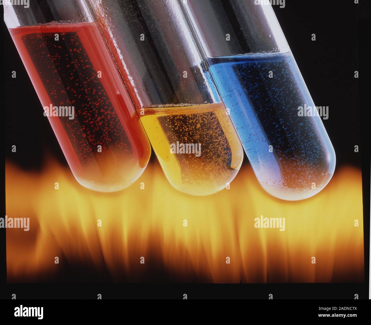 Laboratory glassware. Close-up of three coloured test tubes being ...