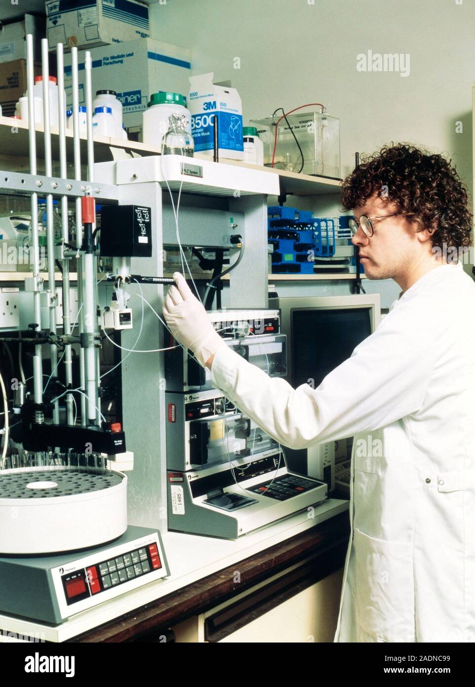 Fast protein liquid chromatography. A scientist adjusts equipment used ...