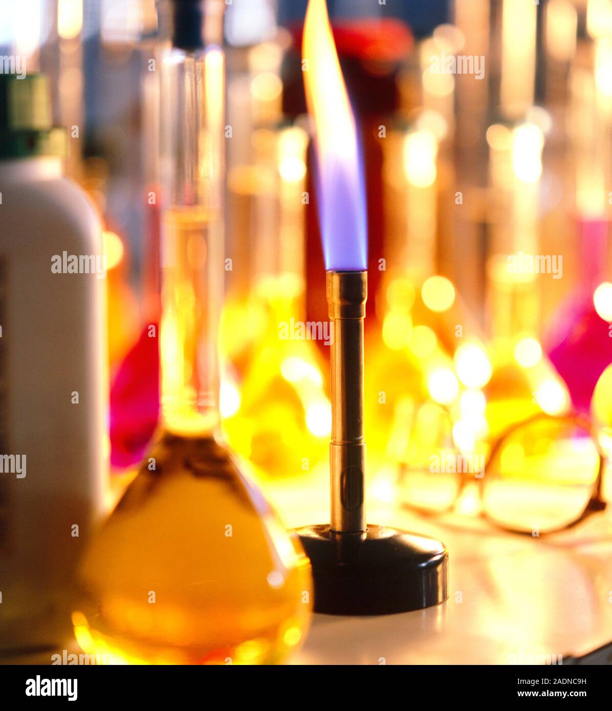 Bunsen burner. Lit bunsen burner with volumetric flasks, and safety ...