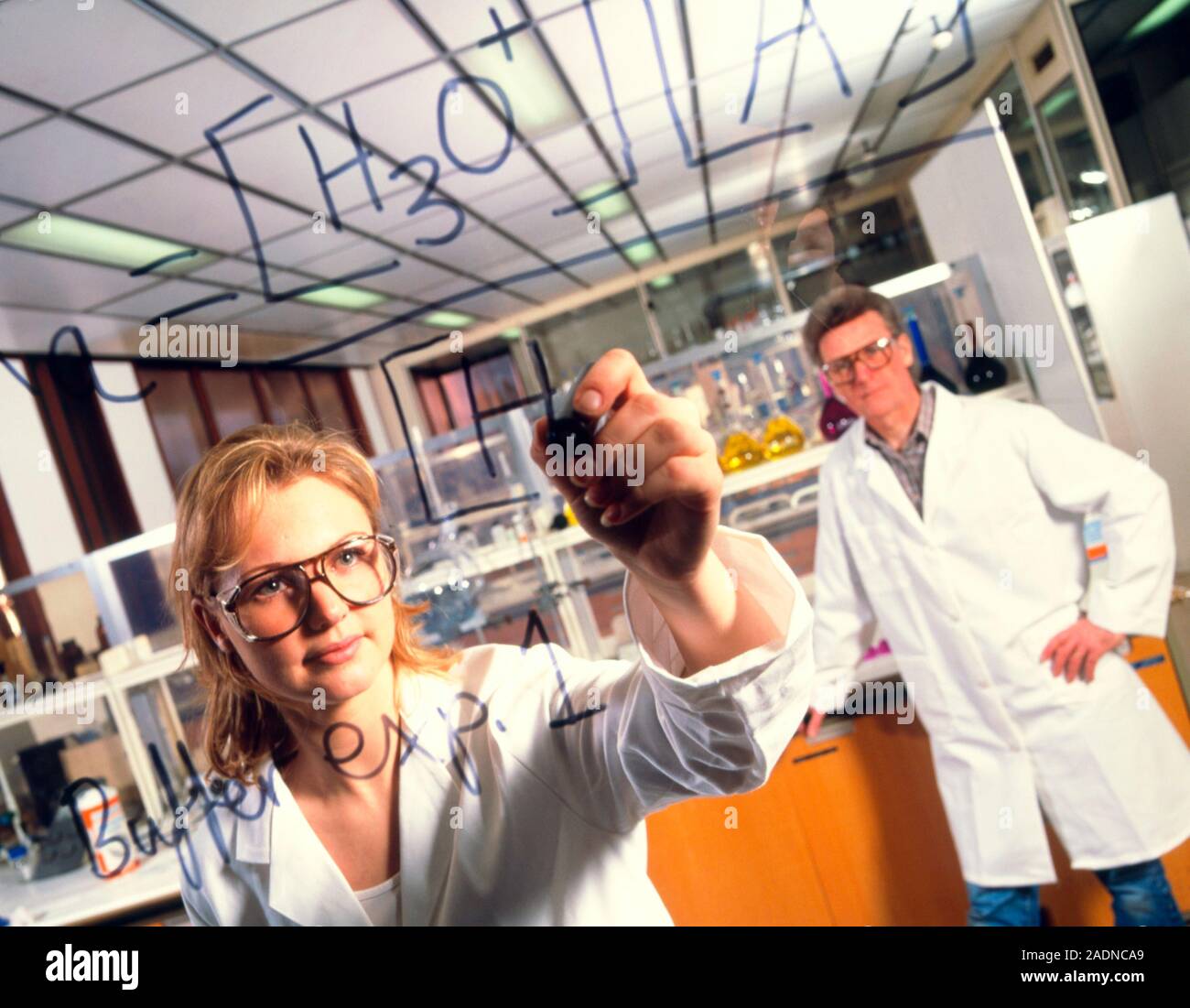 Chemical formula. Female scientist in a laboratory writes a chemical ...