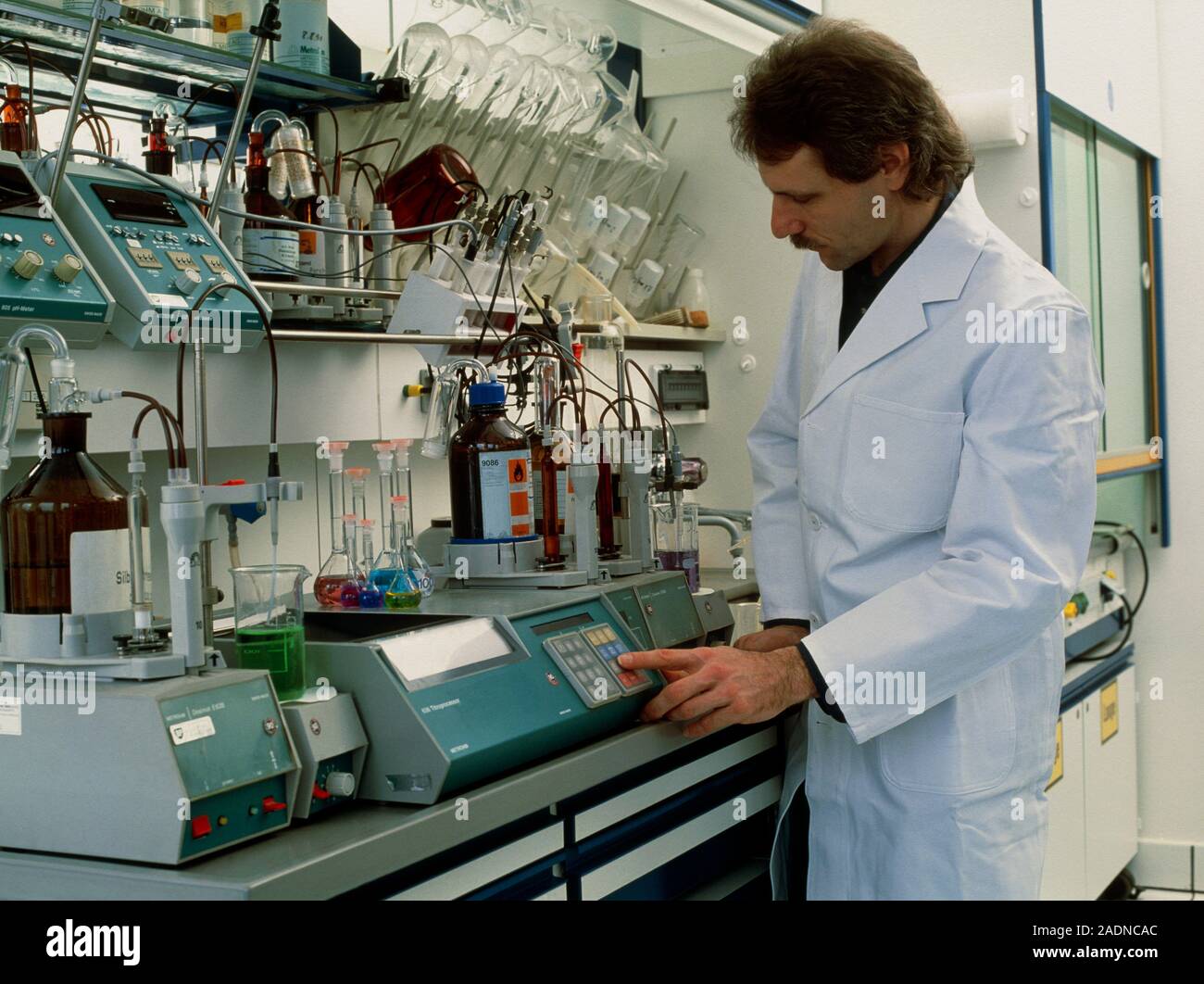 Automated titration. Chemist with a computer-controlled system for ...