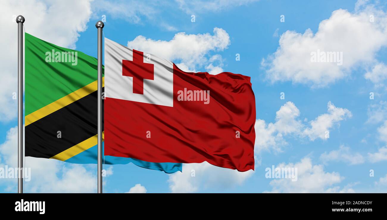 Tanzania and Tonga flag waving in the wind against white cloudy blue ...