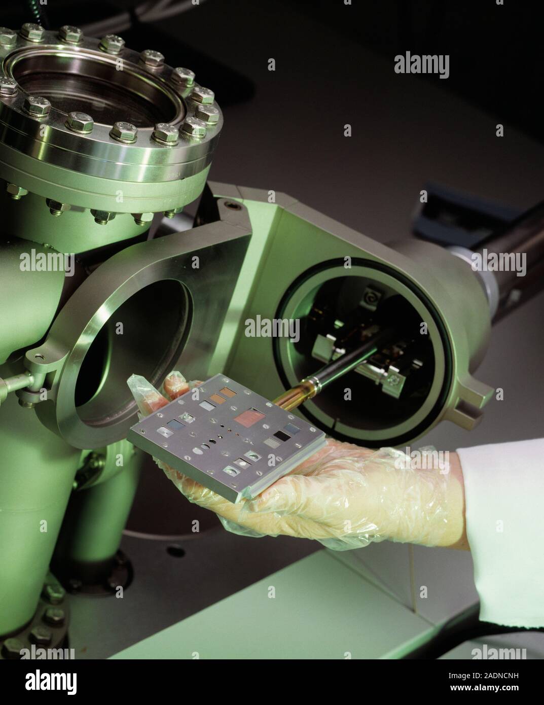 Mass spectrometry. Technician loading a sample tray into a time of ...