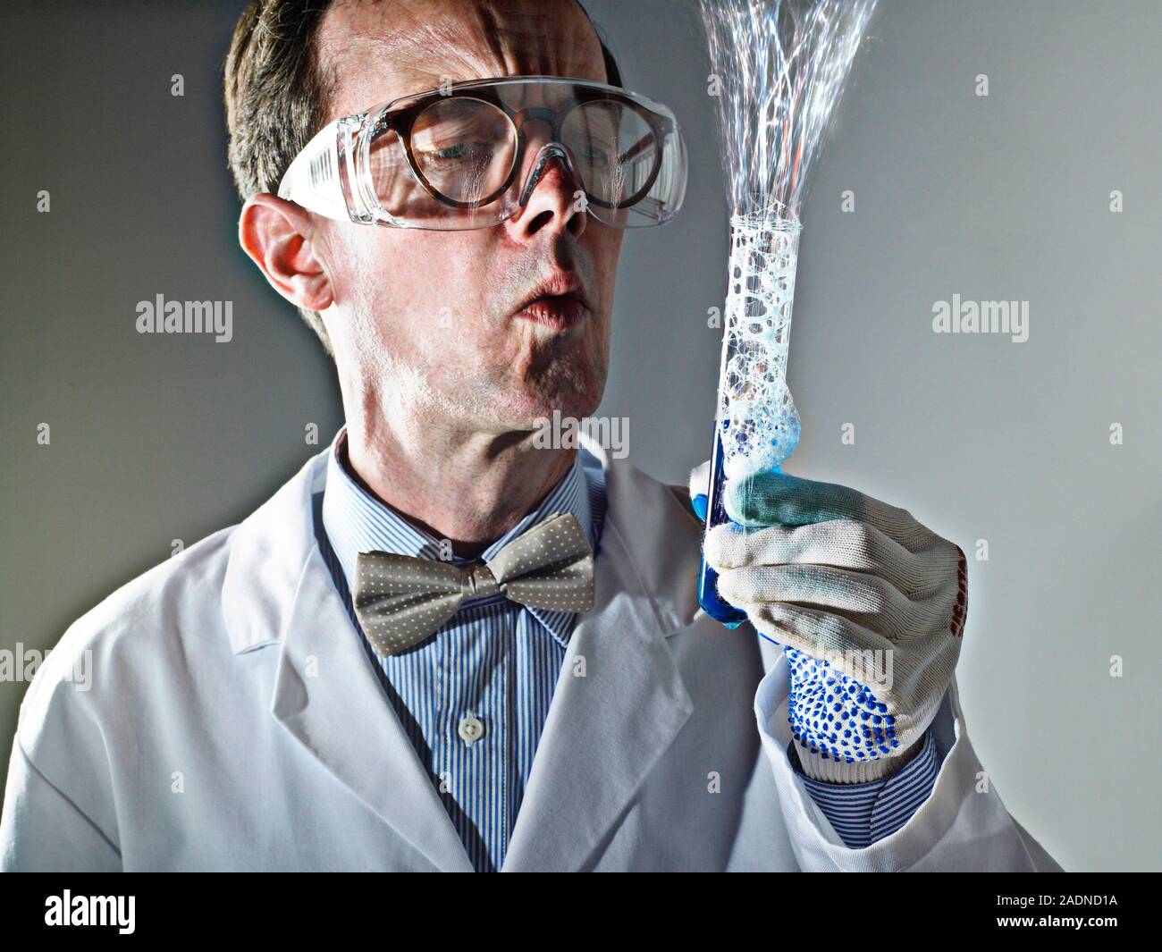 MODEL RELEASED. Mad scientist examining a chemical reaction exploding ...