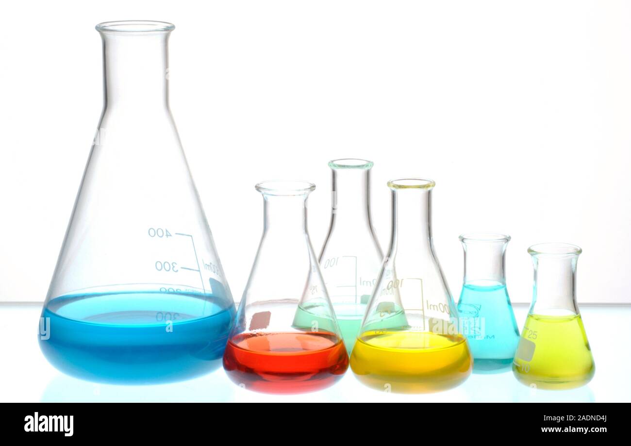 Laboratory chemicals and glassware. Coloured dyes dissolved in water in ...