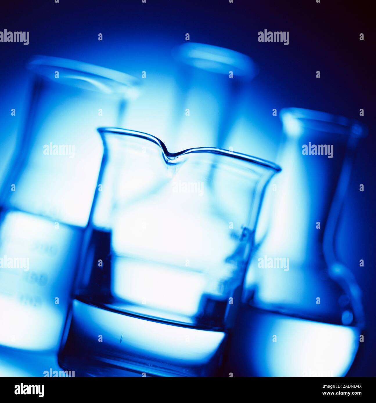 Laboratory glassware. Glass beaker (centre), measuring cylinder (left ...