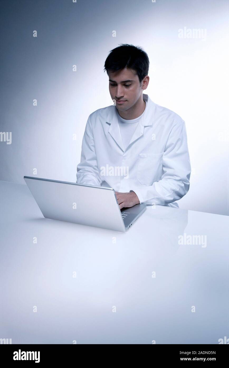 MODEL RELEASED. Scientific research. Laboratory technician typing at a ...