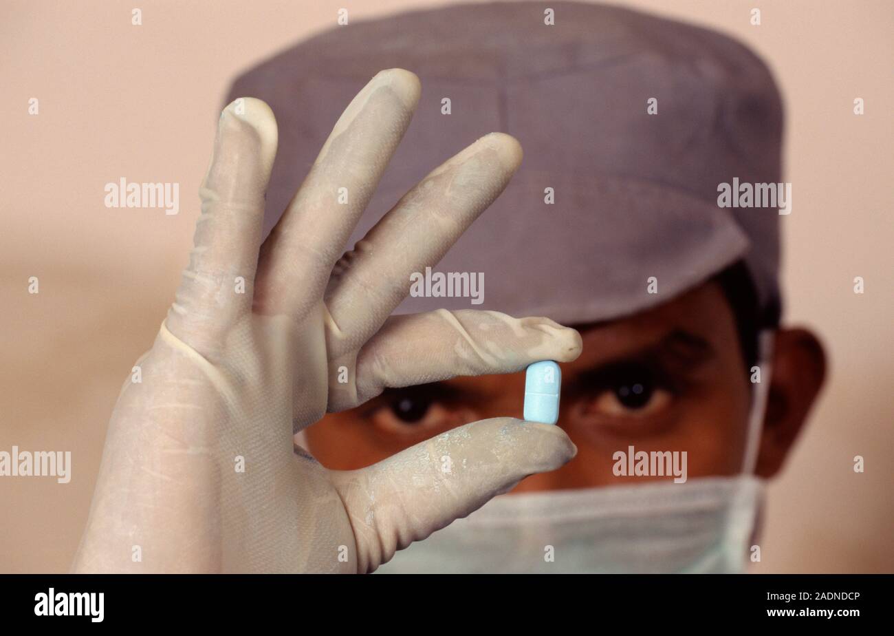 Drug manufacture. Worker holding a pill at a factory in Hyderabad ...