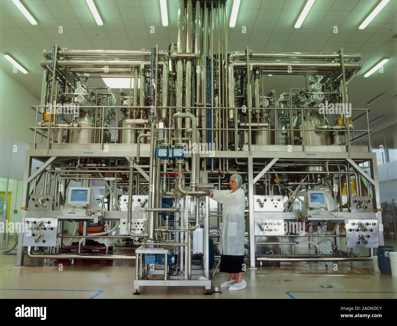 Cosmetics factory. Worker adjusting machinery at a cosmetics factory ...