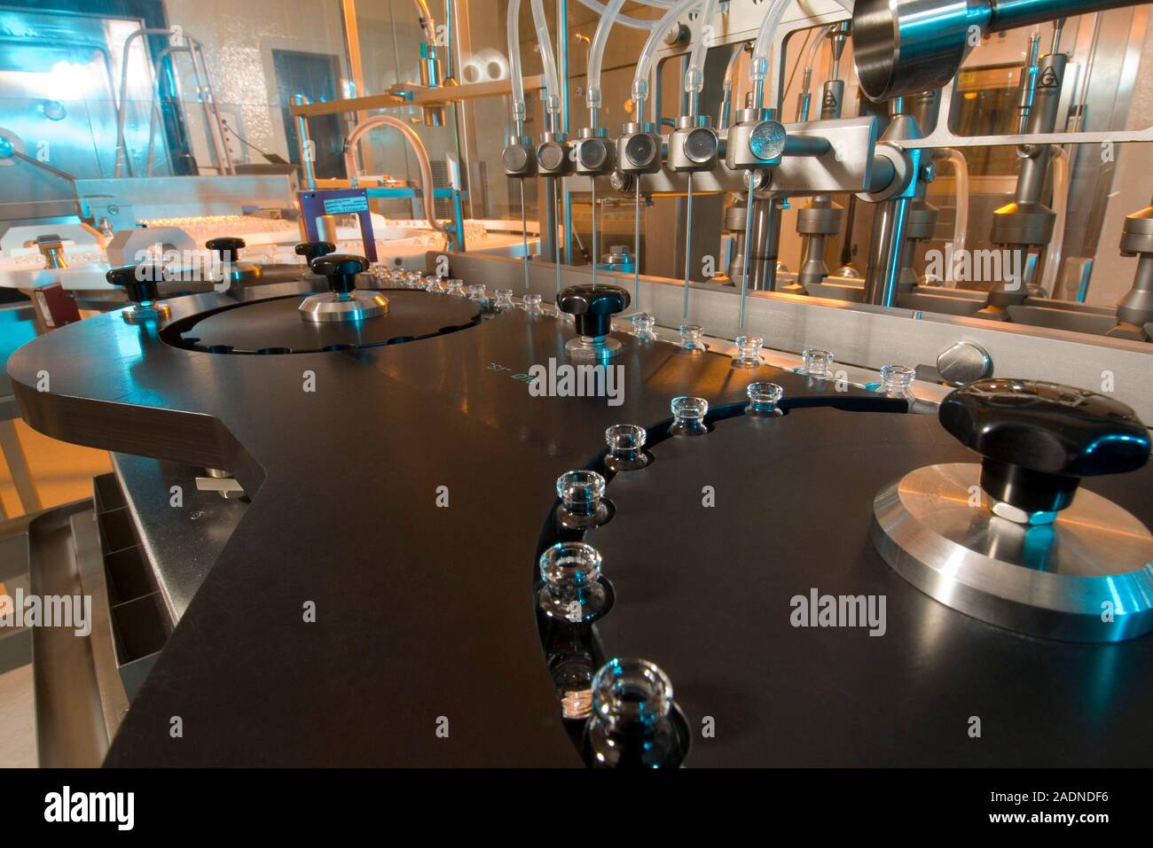 Automated vial filling machine. Empty, sterilised vials being filled by ...