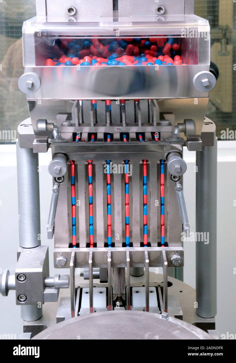 Drug manufacture. Pill dispersal unit filling and sealing blue and red ...