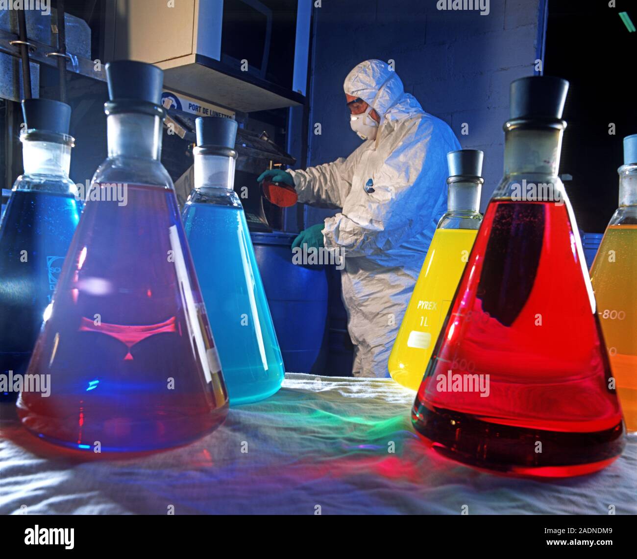 Textile industry. Laboratory worker in a protective suit preparing dyes ...