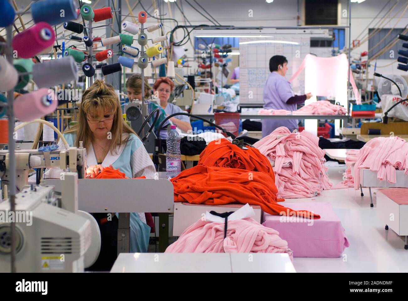 Textile industry. Workers using sewing machines to assemble the final ...