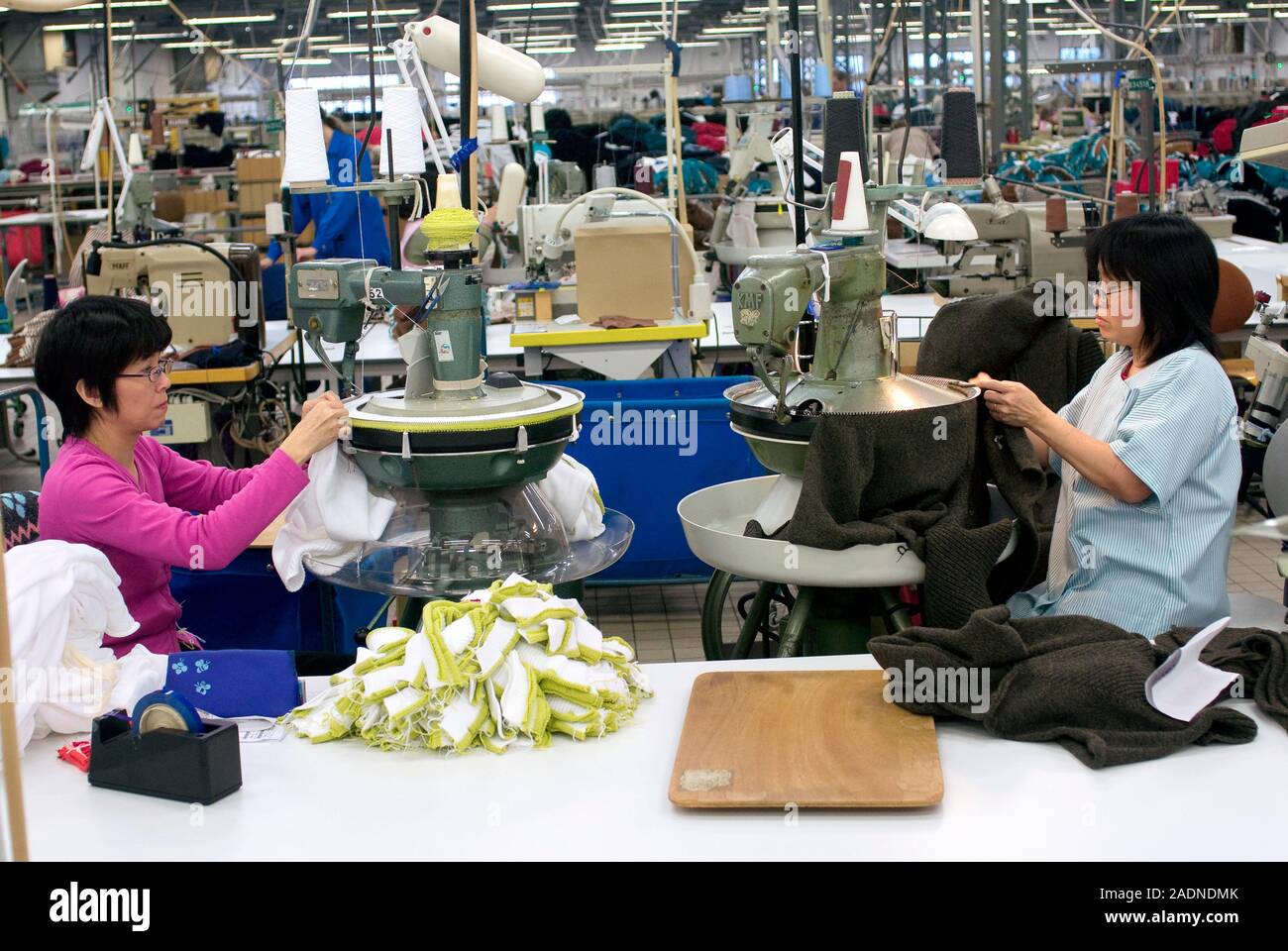 Textile industry. Workers using circular sewing machines to assemble ...