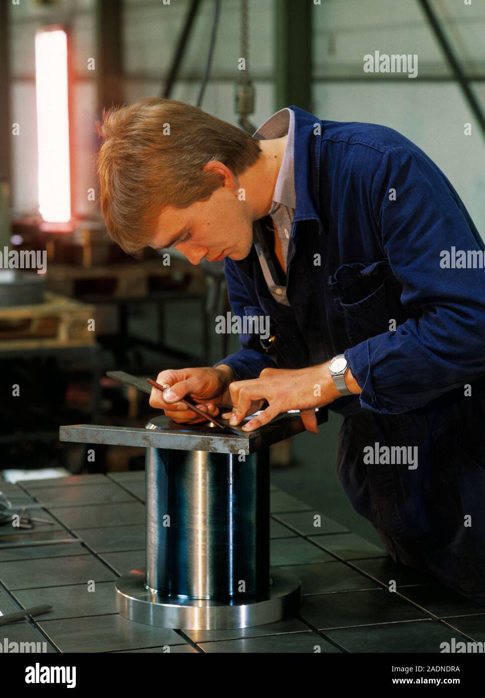 Toolmaking. Machine operator marking out points for machining a bearing ...