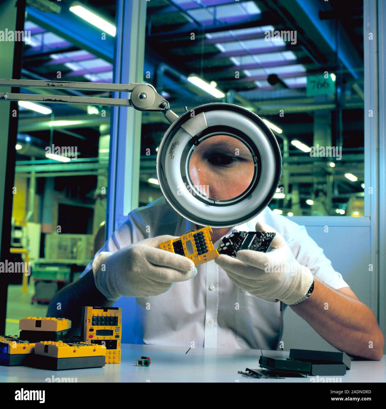 Programmable Lego manufacture. Technician inspecting soldering on a ...
