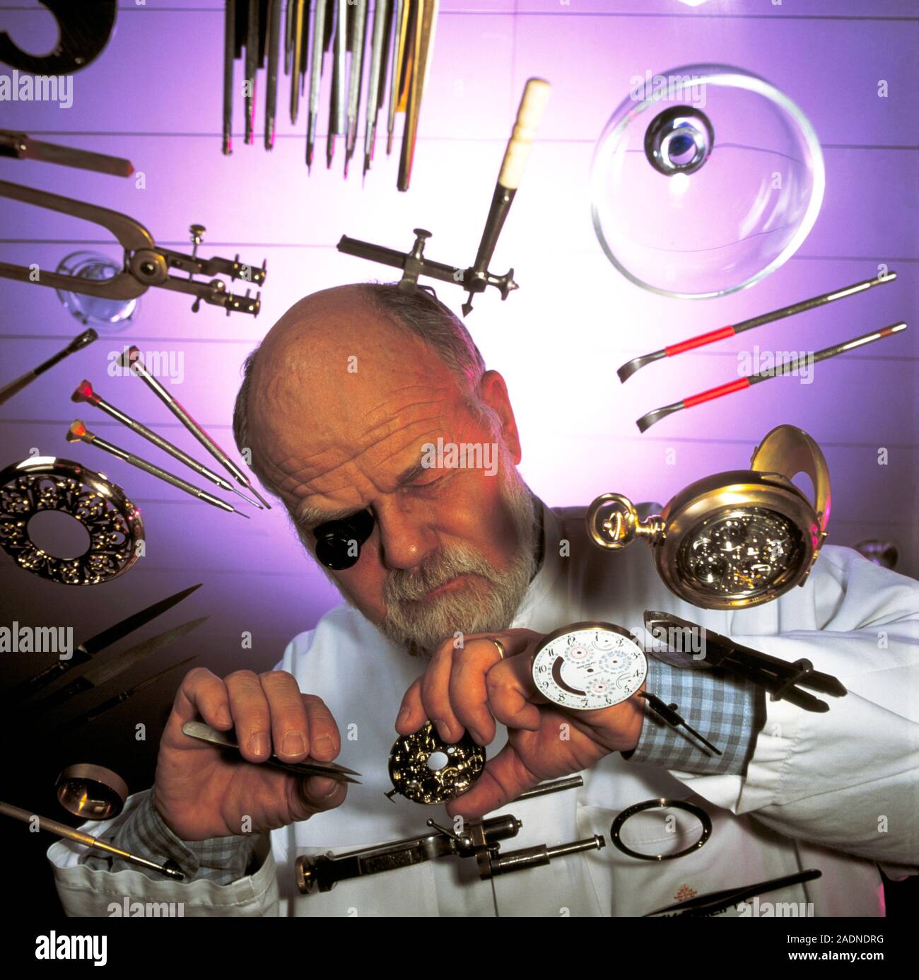 Watchmaker. Master watchmaker assembling a watch. He is inserting a ...