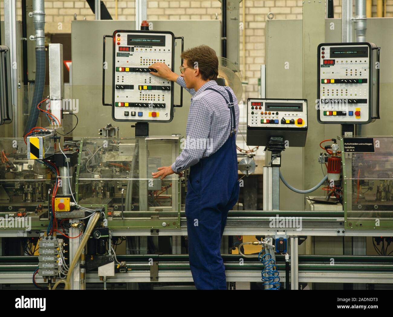 Automated factory machinery. Technician at the controls of an automated ...