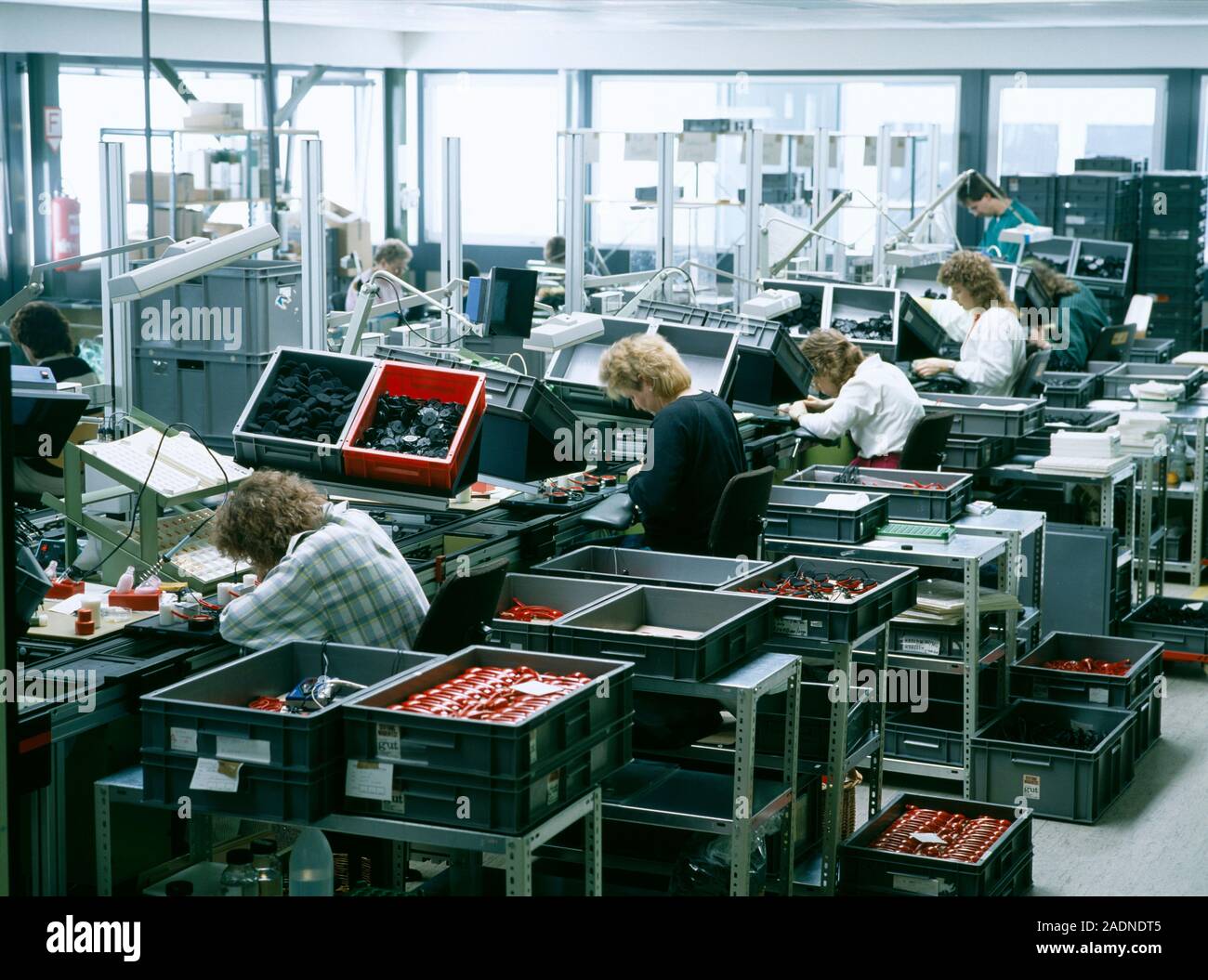 Assembly line. Women on a production line assembling the components of ...