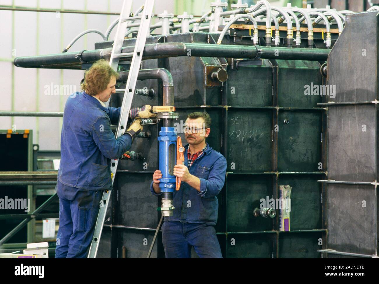 Assembling an industrial furnace. Mechanical engineers constructing an ...