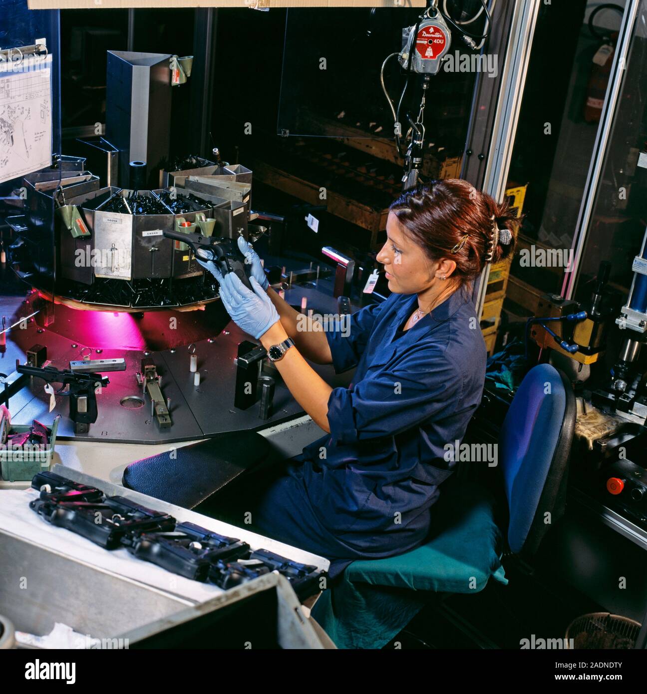 Assembly. Worker assembling a beretta 92F 9mm semi-automatic pistol ...