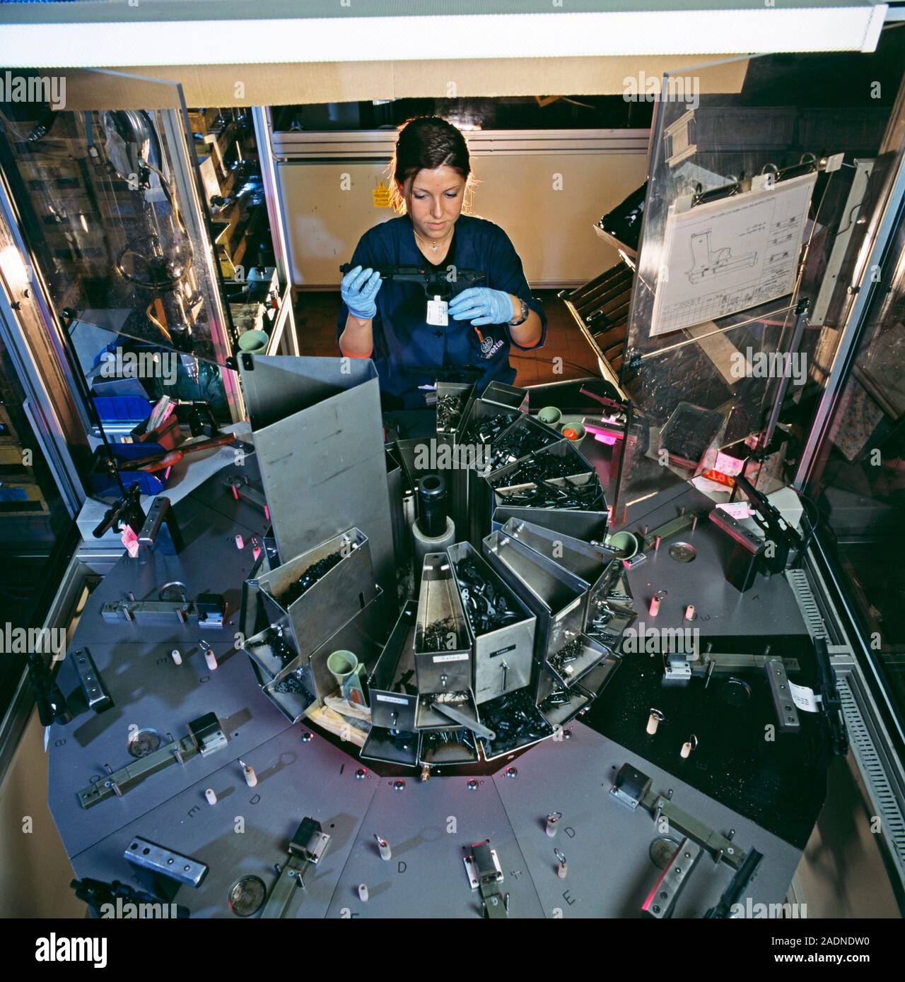 Assembly. Worker assembling a beretta 92F 9mm semi-automatic pistol ...