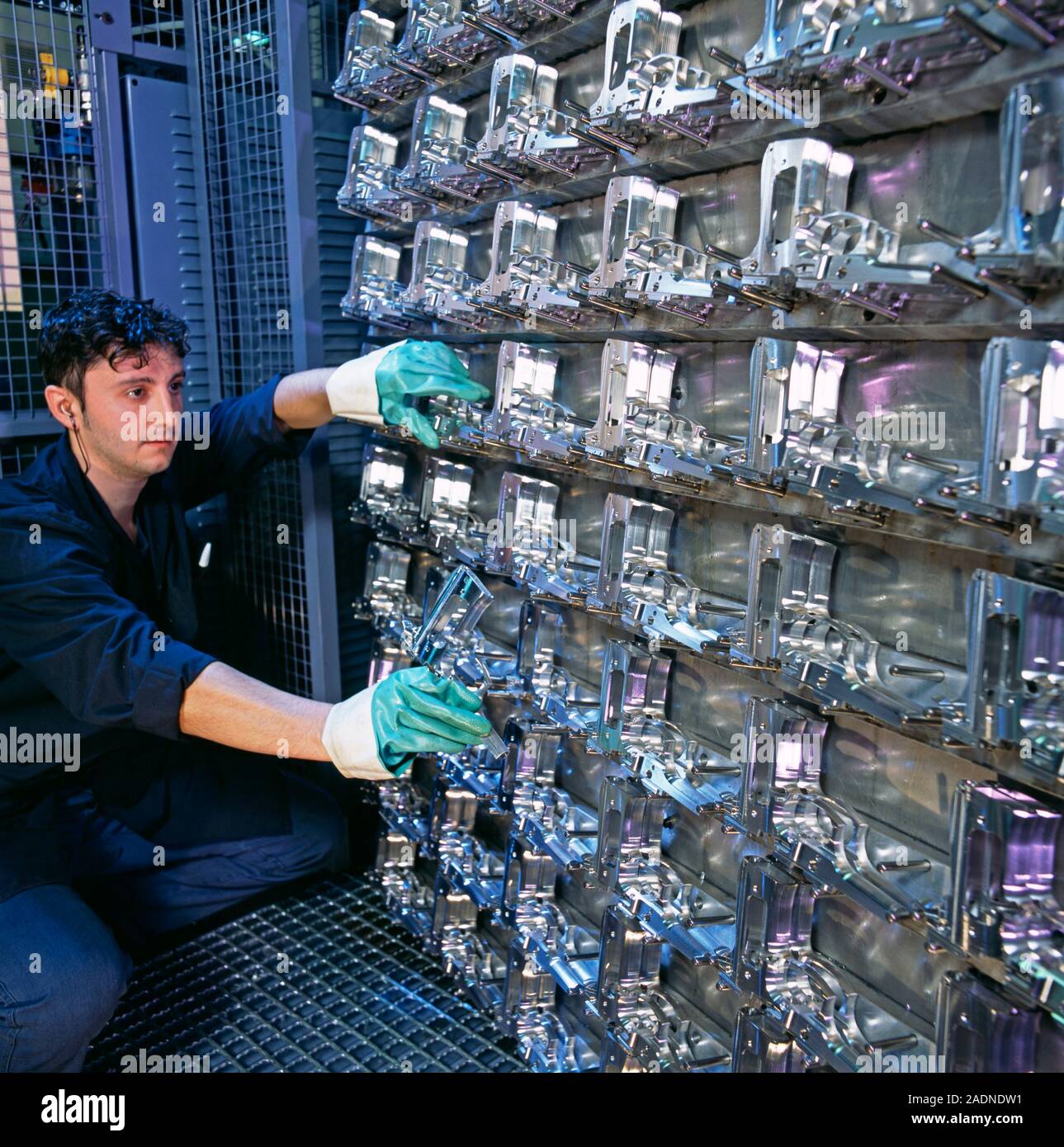 Gun manufacture. Worker loading trays with the shells of beretta 92F ...