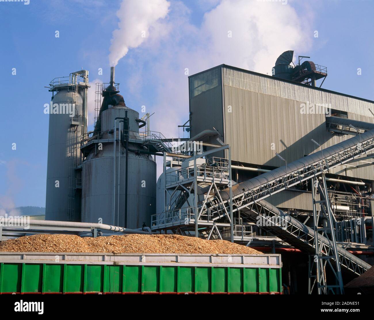 Paper mill. A container of wood chips outside a paper mill. Paper is ...